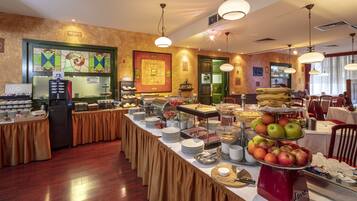 Disposição de buffet com diversos alimentos e uma estação de café.