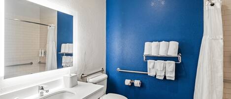 Casa de banho com lavatório branco, sanita e parede com detalhe azul.