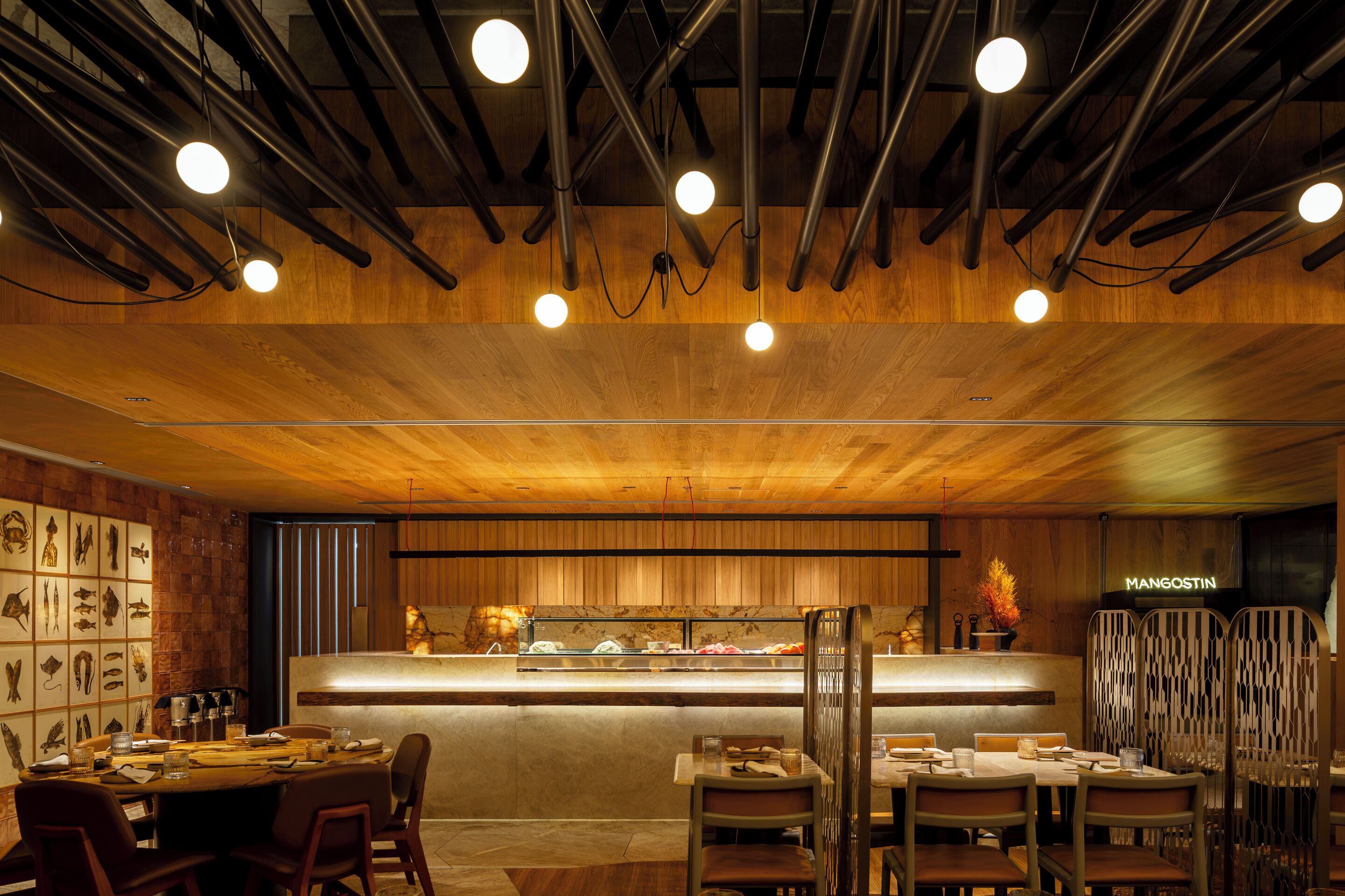 Interior moderno de restaurante com vigas de madeira no teto, área de bar central e disposição de mesas para os hóspedes.