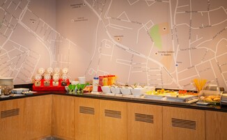 Disposição de buffet com diversos alimentos e um mapa na parede.