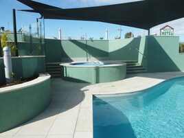 Piscina com hidromassagem e área de estar coberta.