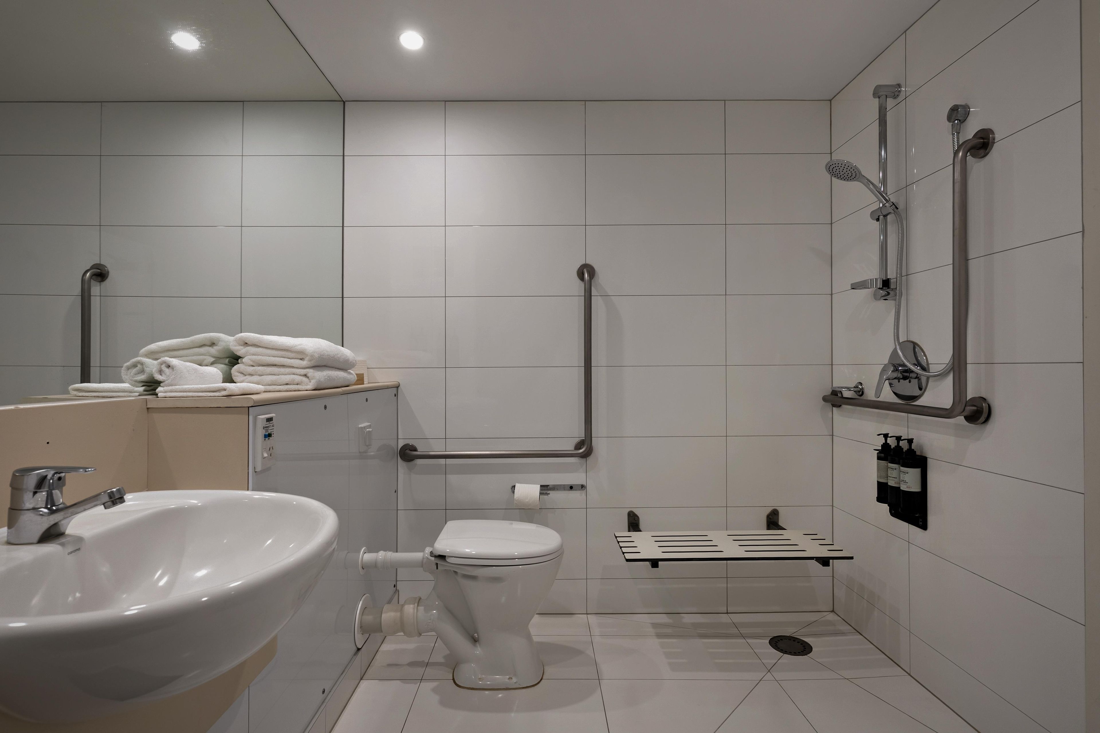 Casa de banho moderna com lavatório branco, sanita e zona de duche.