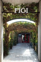 Um arco com a palavra 'FIGI' acima, dando acesso à entrada de um edifício.
