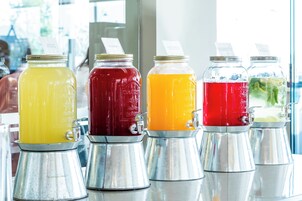 Uma fileira de dispensadores de bebidas com cores variadas.