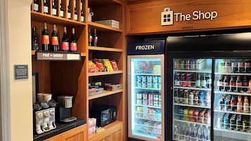 Uma loja com prateleiras de vinho, um freezer e uma geladeira repletos de bebidas.
