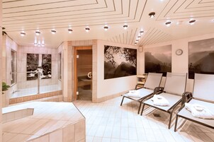 Um spa moderno com banheira, duas poltronas e um grande painel decorativo na parede.