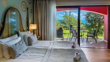 Quarto de hotel com cama, mesa de cabeceira, luminária e vista para o exterior.