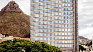 Um edifício de hotel alto, com fachada curva e um letreiro grande no terraço.
