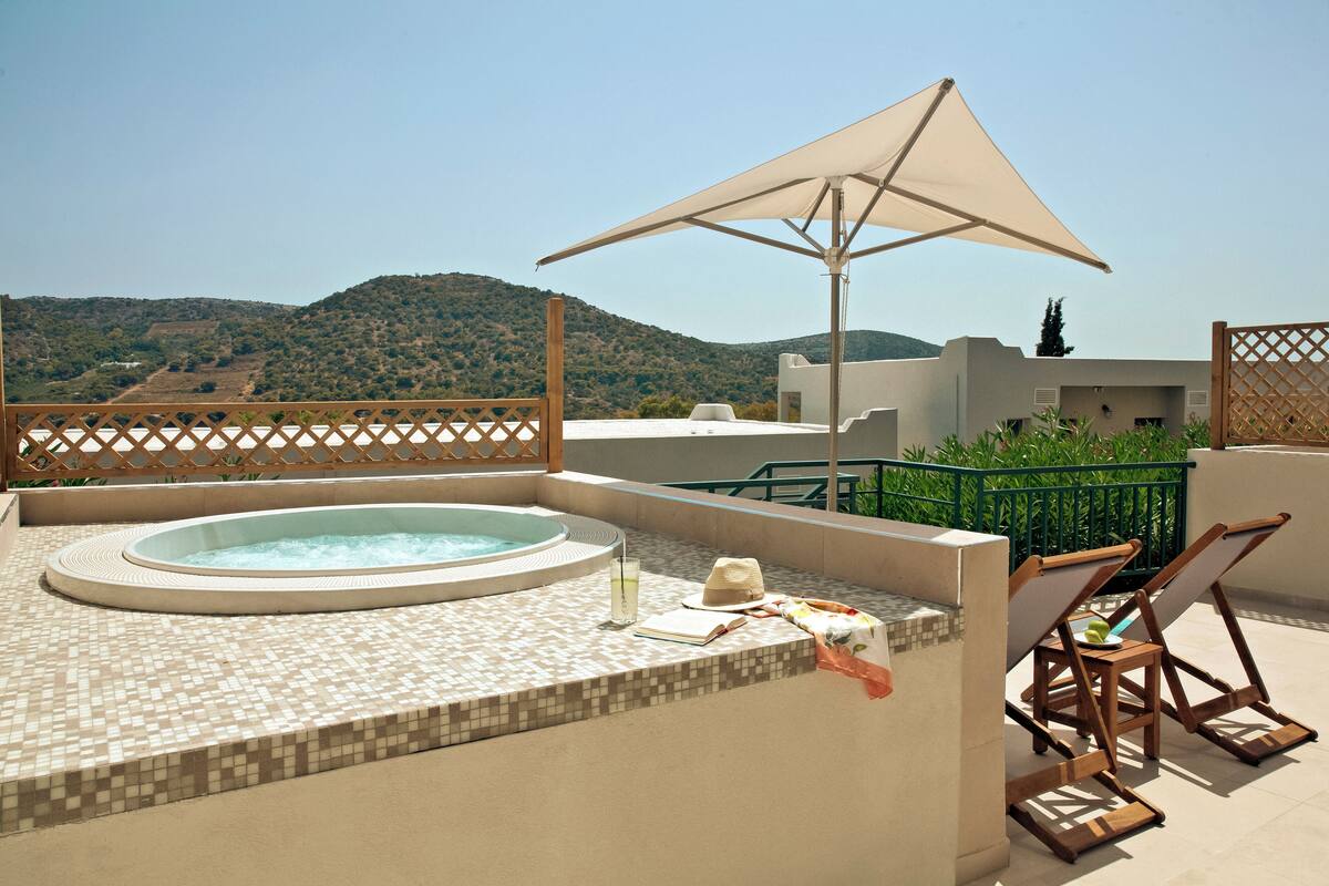 Terraço no telhado com hidromassagem, espreguiçadeiras e vista para as colinas.