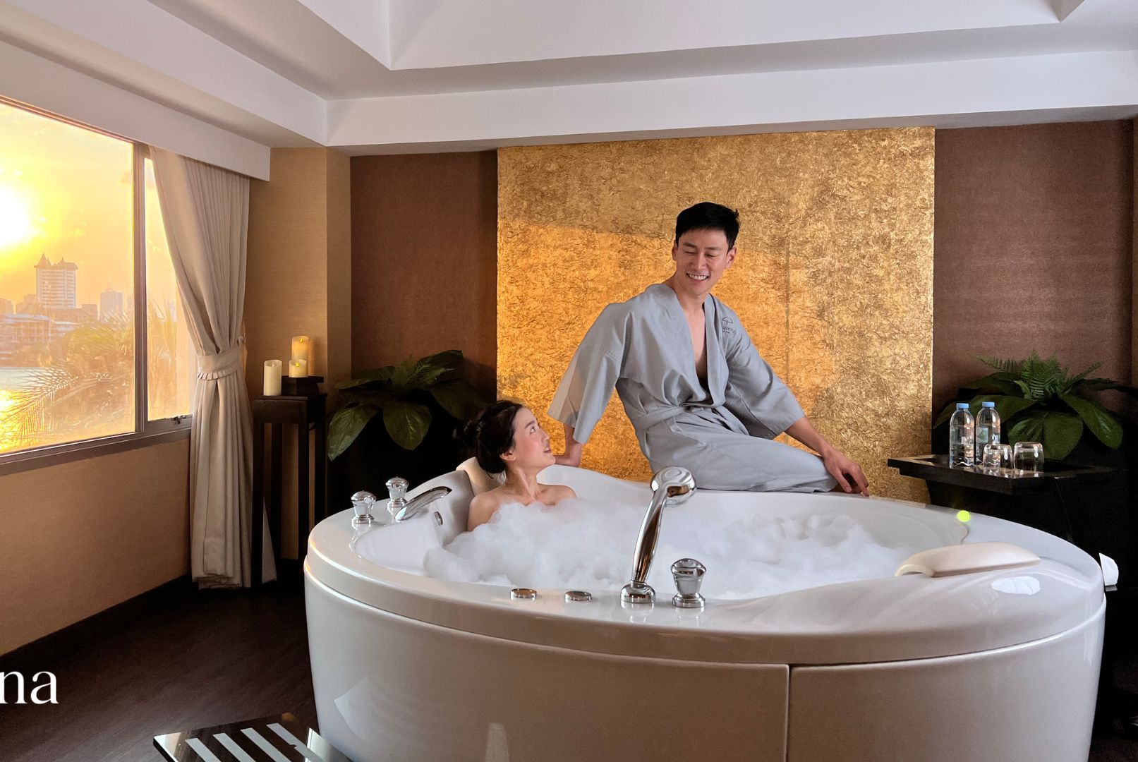 Um quarto de spa com uma banheira grande, vista para a cidade e uma placa indicando o número do quarto.