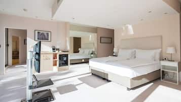 Quarto de hotel moderno com uma cama grande, mesas de cabeceira, um espelho e uma televisão.