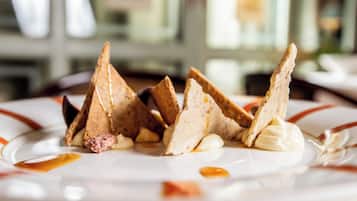 Um prato de comida com biscoitos triangulares e uma porção de creme.