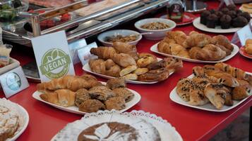 Buffet com diversos alimentos, incluindo doces e sobremesas.