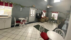 Quarto com piso de azulejos, móveis brancos, ventilador de teto e uma porta com a inscrição 'EXIT'.