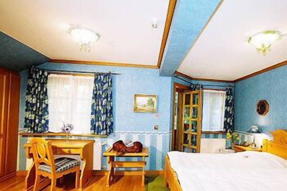 Um quarto com uma cama, uma escrivaninha e uma cadeira.