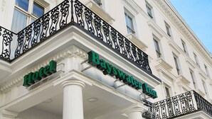Entrada de hotel com varanda e colunas.