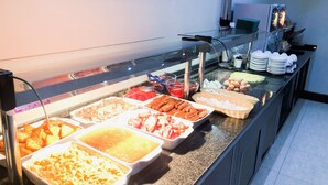 Um buffet com diversos pratos e acompanhamentos.