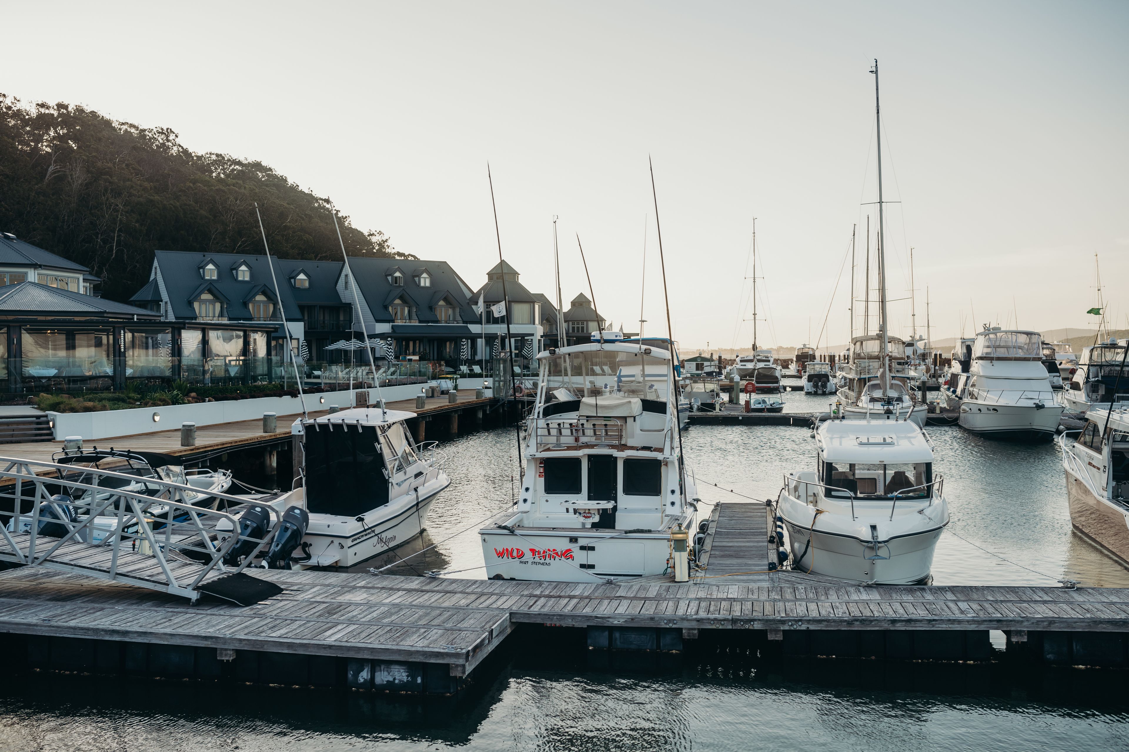 Uma marina com vários barcos atracados em cais de madeira.