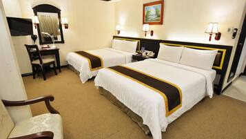 Quarto de hotel com duas camas, uma escrivaninha, uma cadeira e um espelho.