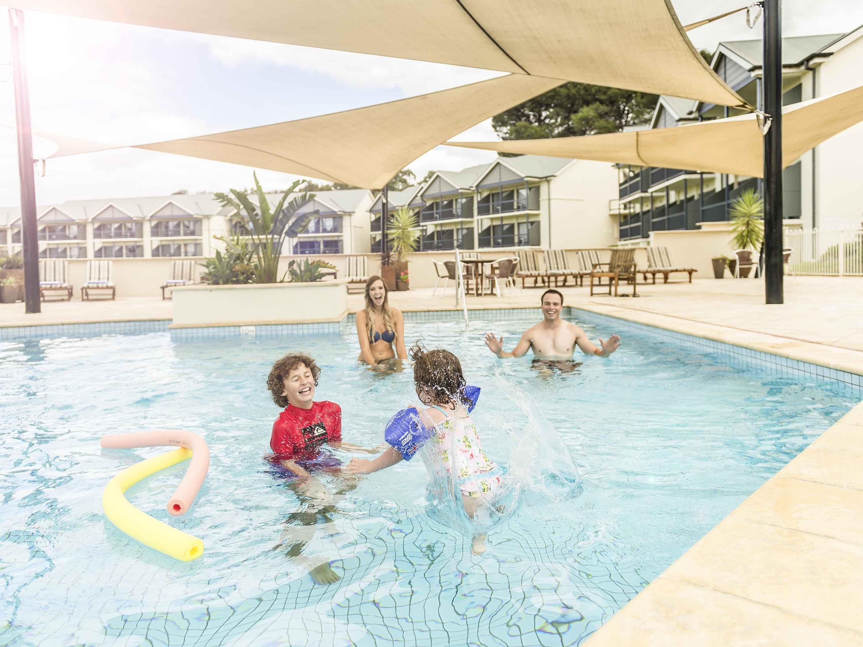 Uma área de piscina com espreguiçadeiras e guarda-sóis.