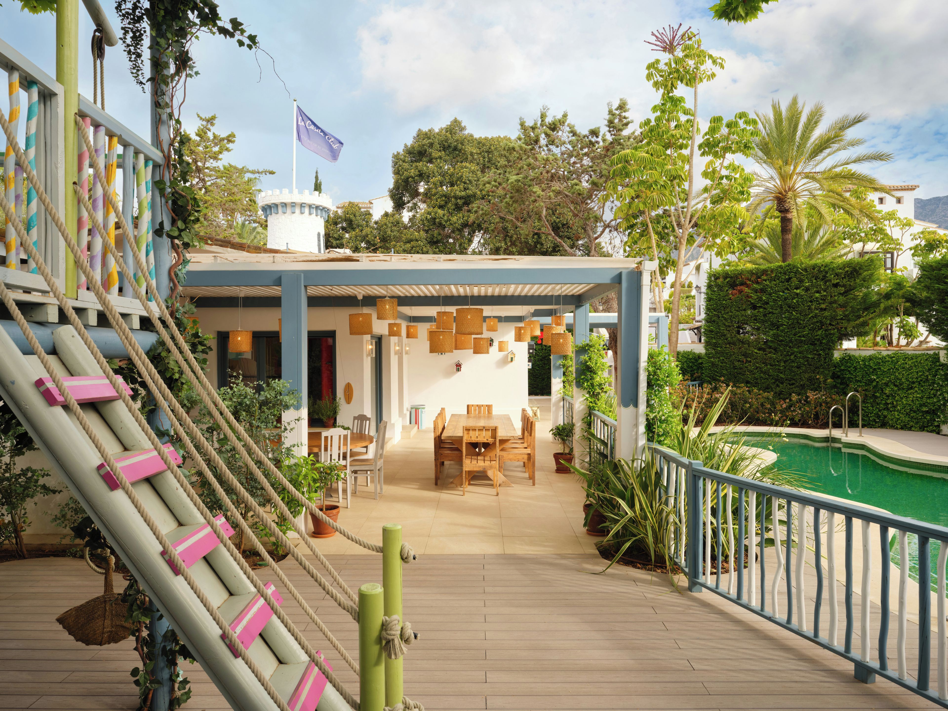 Área externa coberta com piscina, deck de madeira e baloiço.