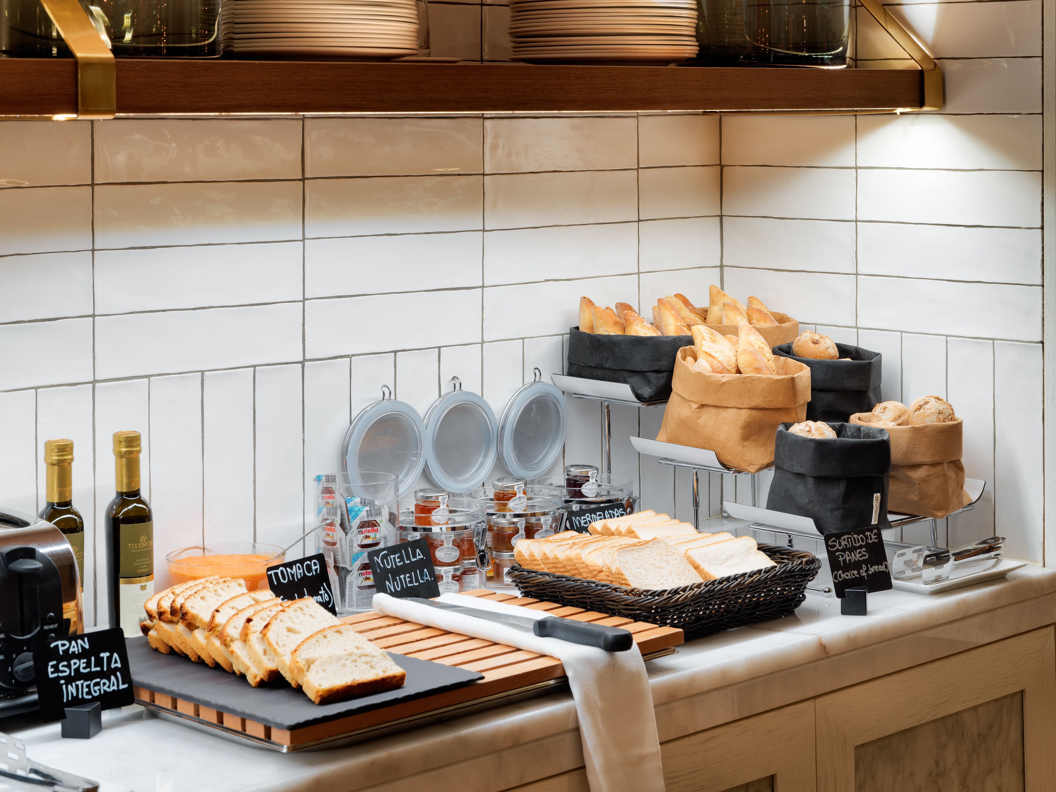 Um buffet de café da manhã com pães, bolos e acompanhamentos.