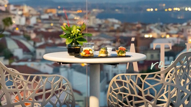 Uma mesa com vista para a paisagem urbana, incluindo edifícios e um corpo d'água.
