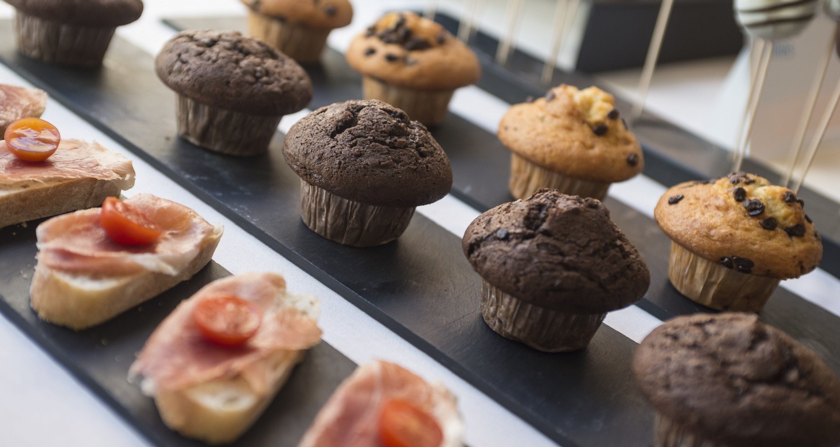 Diversos muffins e doces em uma bandeja.