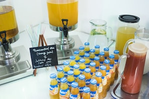 Uma estação de bebidas com diversas opções e um aviso listando os sabores disponíveis.