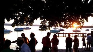 Um grupo de pessoas à beira-mar ao pôr do sol.