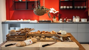 Uma bancada de cozinha com diversos produtos de panificação, uma tábua de corte e utensílios de cozinha.