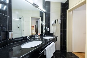 Uma casa de banho moderna com duas bacias, um secador de cabelo e um espelho.