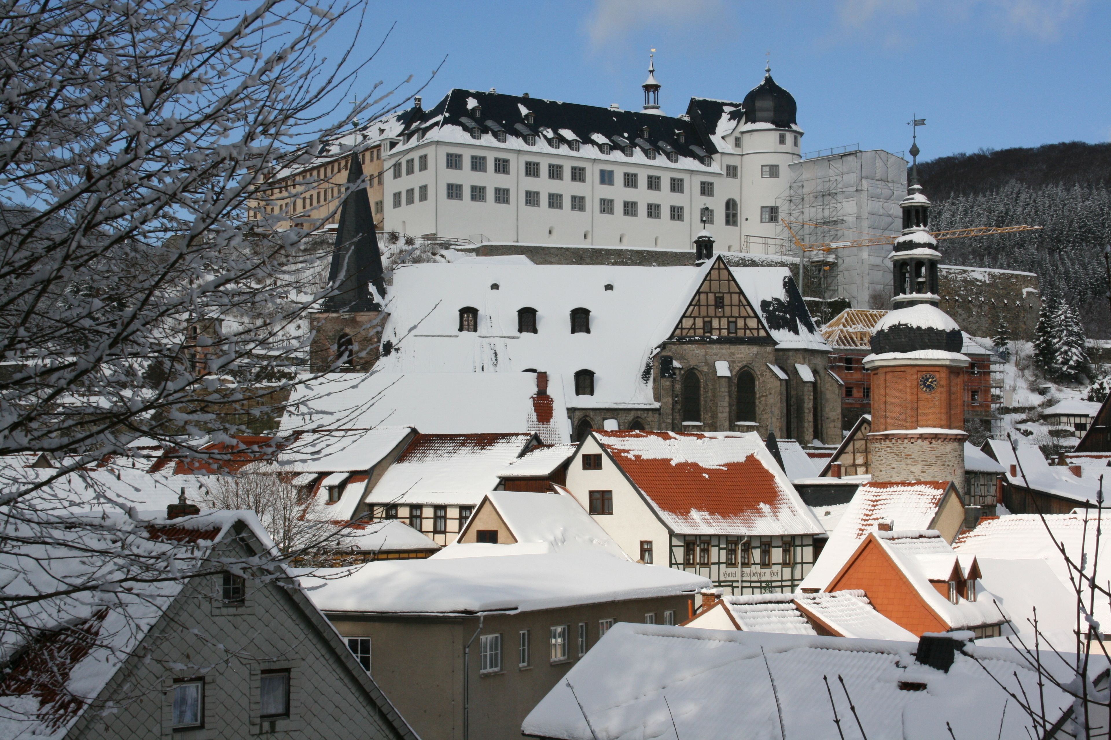 Uma cidade histórica com edifícios cobertos de neve e uma torre de igreja imponente.