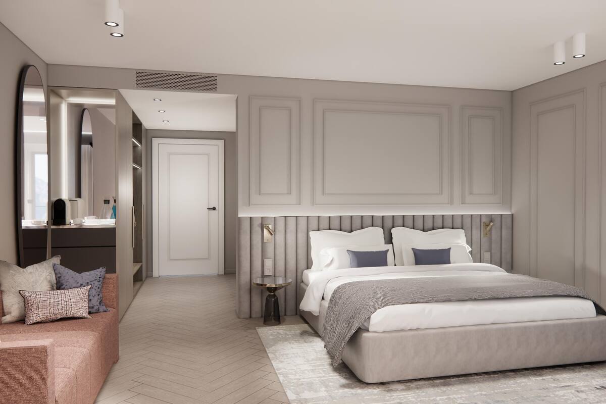 Quarto moderno com uma cama grande, um espaço de estar com sofá e um closet espaçoso.