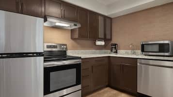 Um frigorífico/congelador grande, um micro-ondas, uma placa de cozinha
