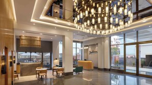 Um hall amplo com balcão de recepção, área de estar e um lustre grande.