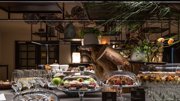 Buffet com diversos tipos de comida, peças de servir em vidro transparente e sinalização indicando opções sem glúten.