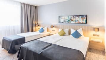 Quarto de hotel com duas camas, uma janela grande com cortinas, um quadro na parede e abajures.