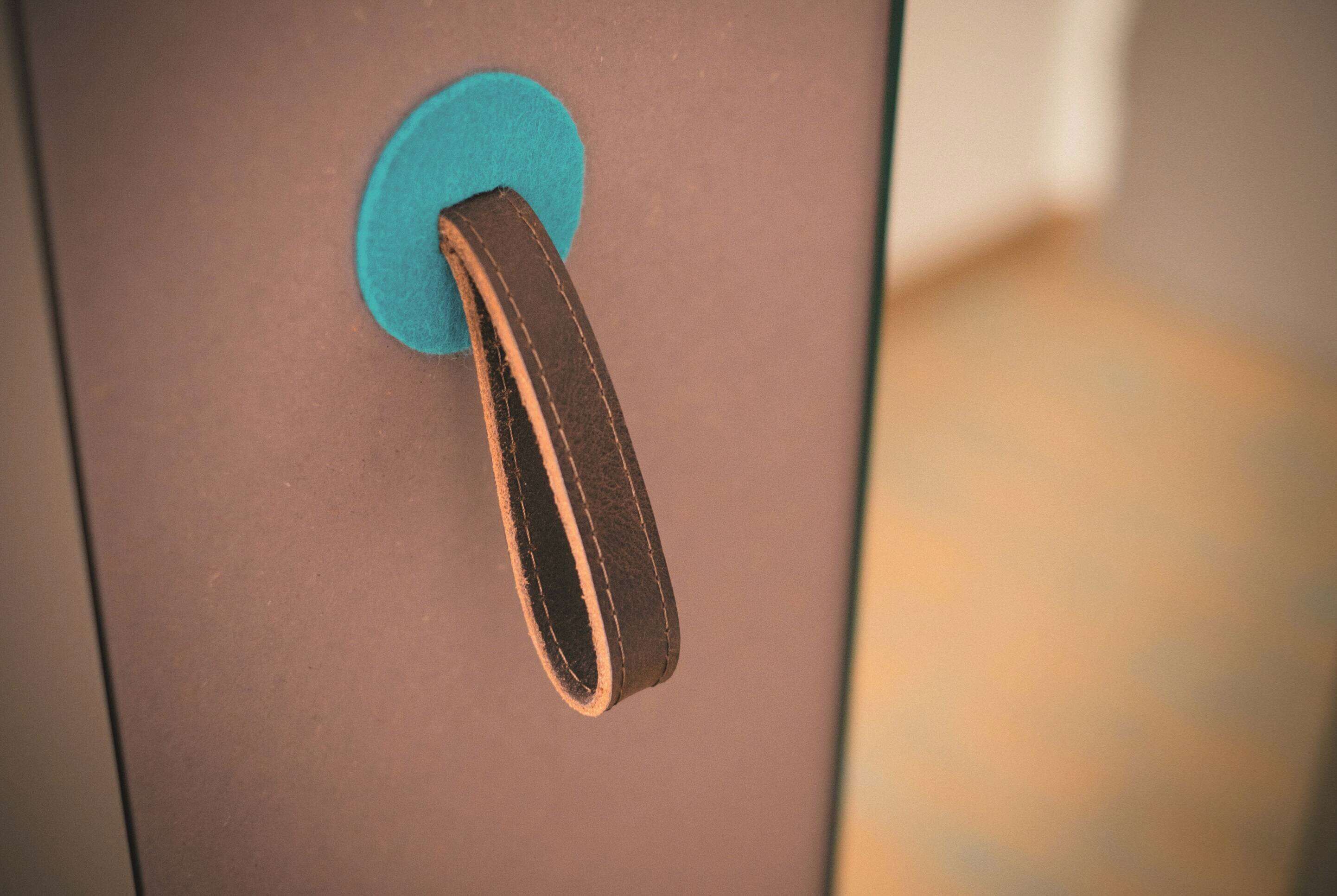 Uma maçaneta presa a uma porta com uma placa azul circular.