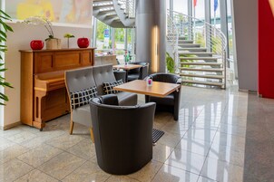Um interior moderno com um piano, área de estar e uma escada.