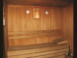 Uma sauna de madeira com bancos e assento embutido.
