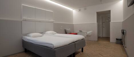 Quarto moderno com uma cama grande, uma escrivaninha e uma cadeira.