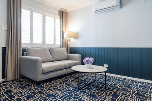 Deluxe 1 Bedroom Apartment | Área de estar | TV 50 polegadas com canais a cabo, Netflix, serviços de streaming