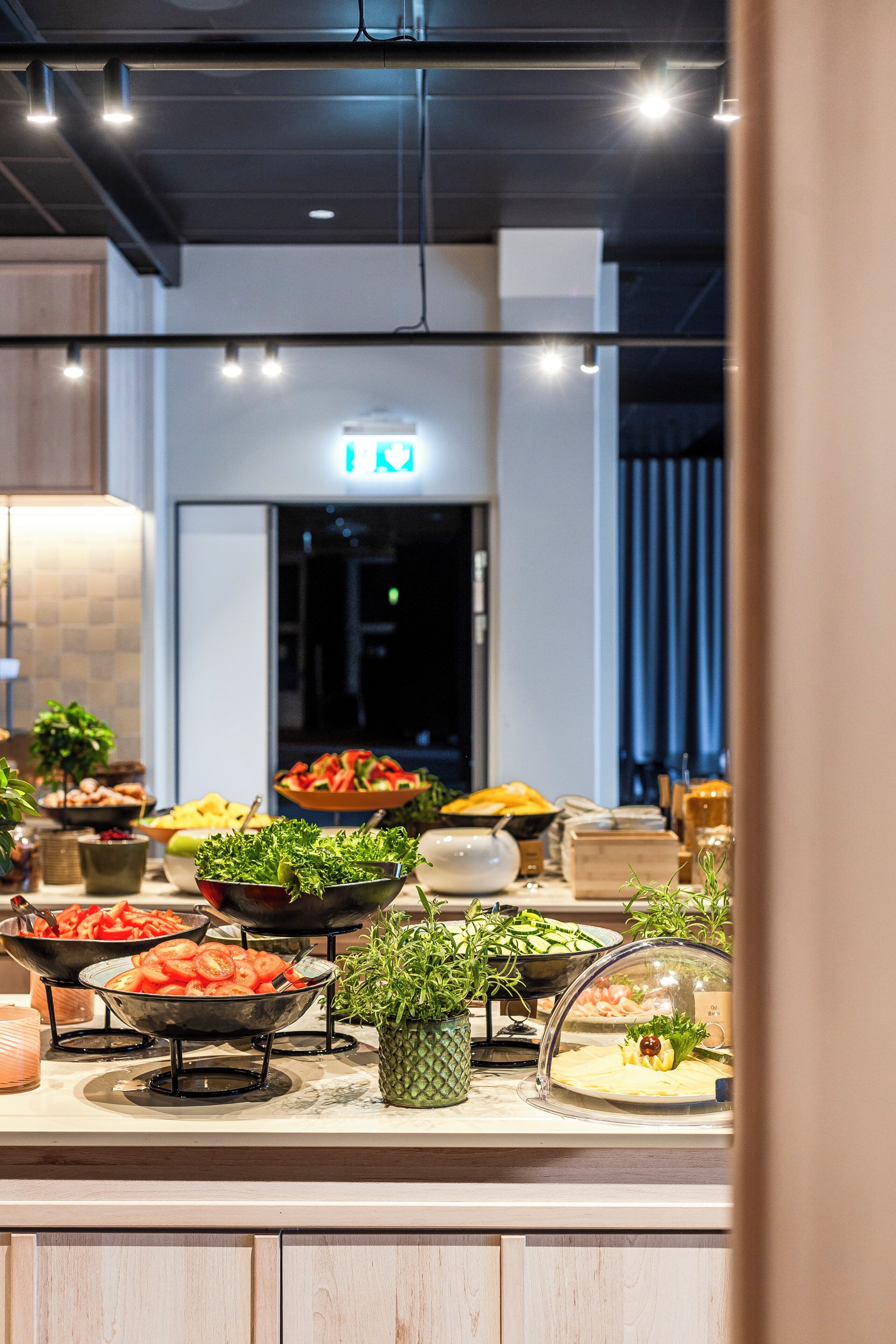 Buffet com diversos alimentos e um vaso de planta.