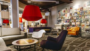 Uma área de estar moderna com sofás, poltronas e uma mesa de centro.