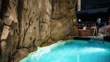 Uma piscina com uma parede de pedra e um relógio.