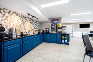 Cozinha moderna com armários azuis, balcão de café da manhã e placa Baymont Breakfast Corner.