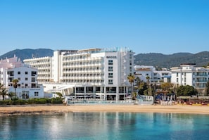 Um hotel com vários andares, área de piscina e vista para a praia.