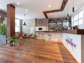 Uma área de bar moderna com relógio, banquetas e balcão.