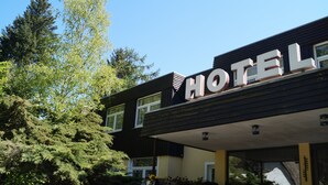 Um hotel moderno com uma placa grande de "HOTEL" na fachada.